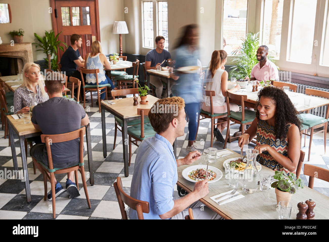 Customers Enjoying Meals In Busy Restaurant Stock Photo - Alamy