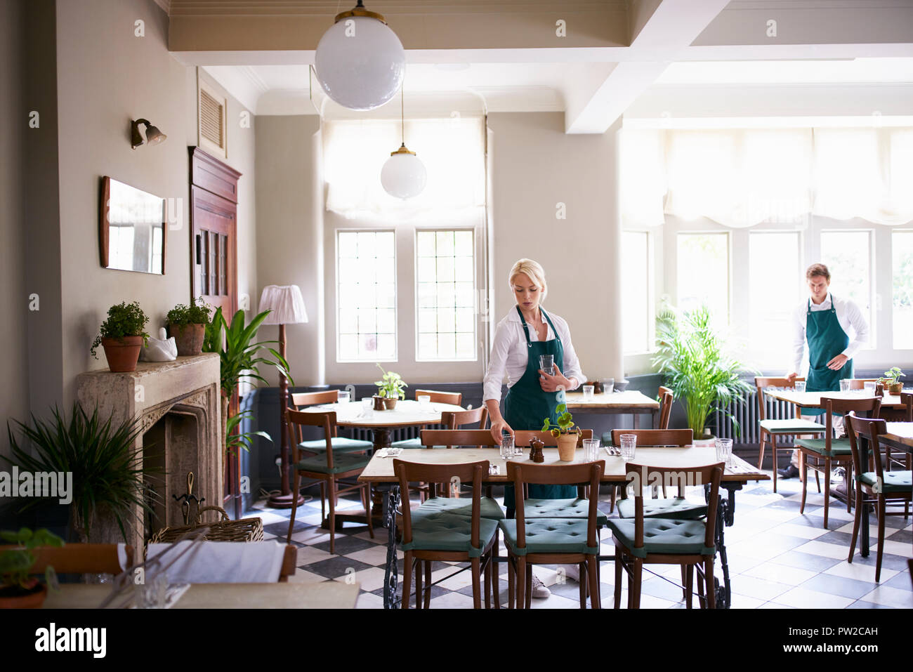 Staff Laying Tables In Empty Restaurant Stock Photo - Alamy