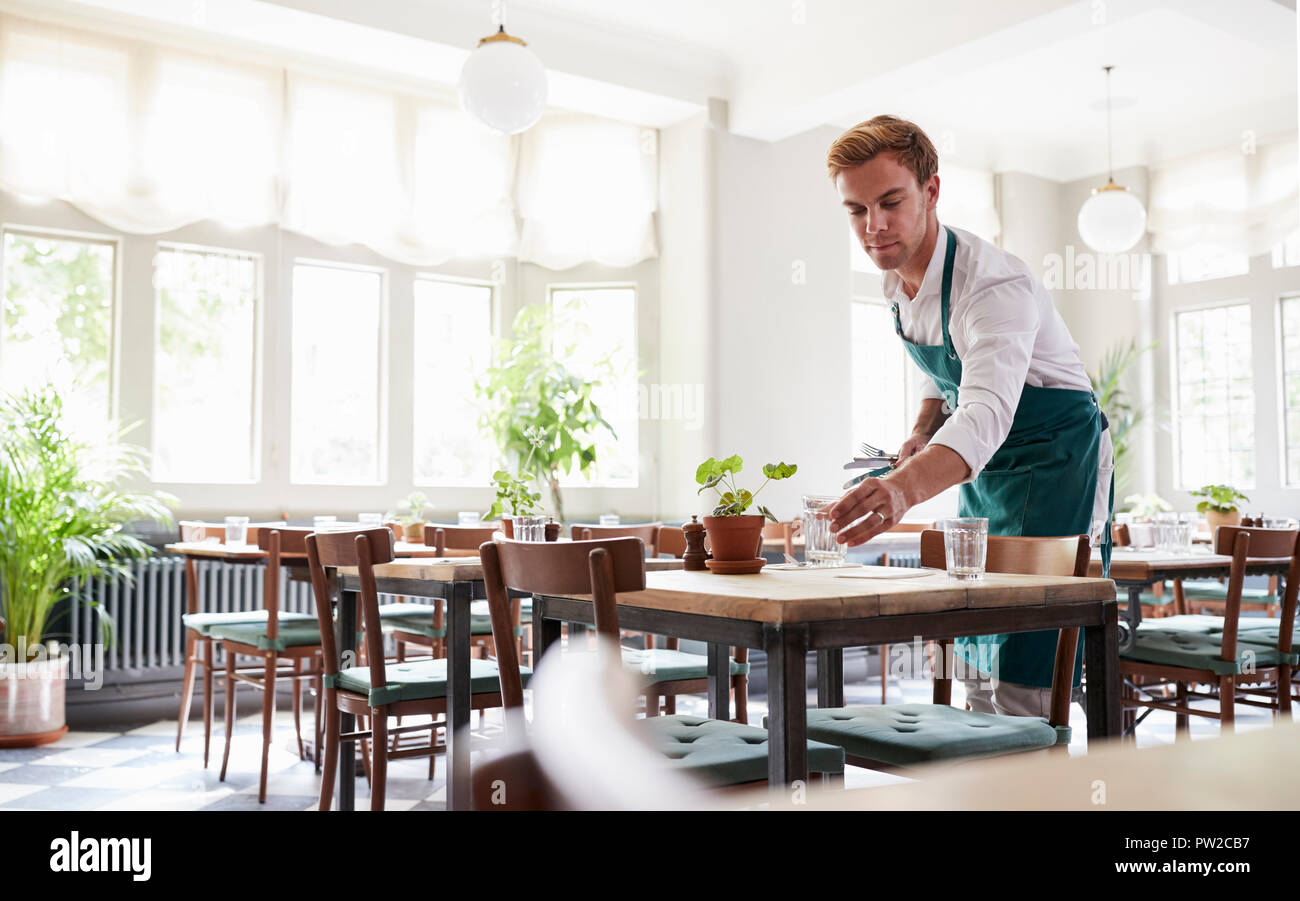 Waiter Laying Tables In Empty Restaurant Stock Photo - Alamy