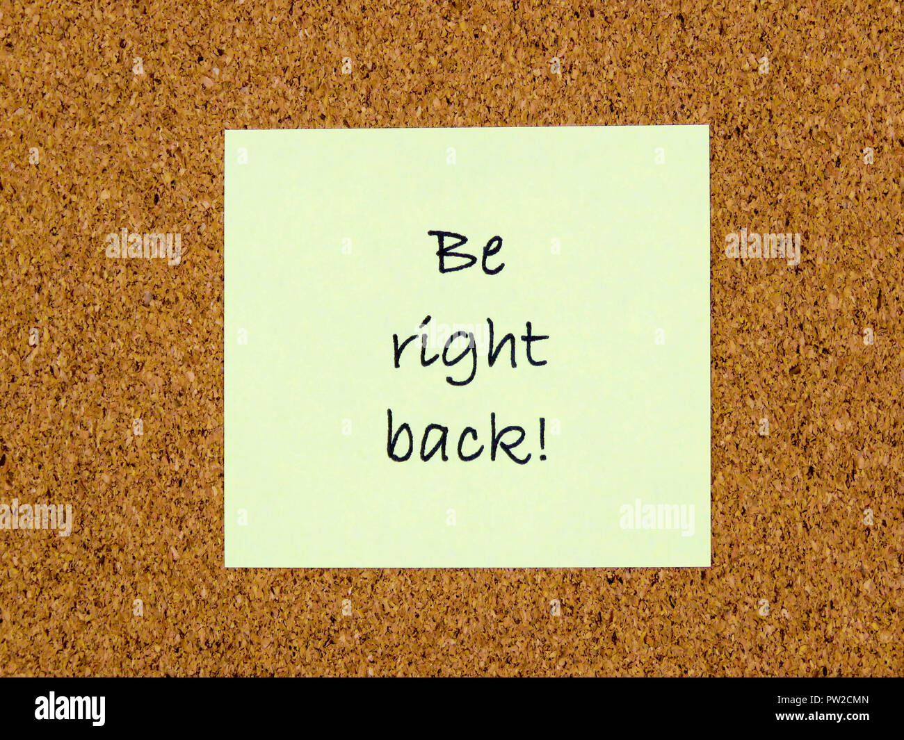 A yellow sticky note with be right back written on it on a cork board ...