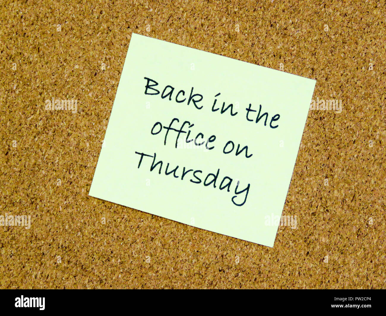 A yellow sticky note with back in the office on Thursday written on it ...
