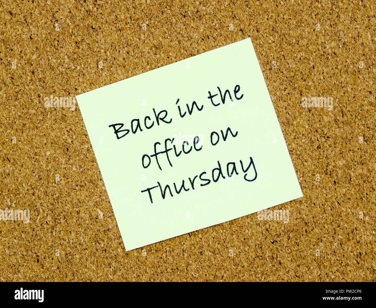 A yellow sticky note with back in the office on Thursday written on it ...