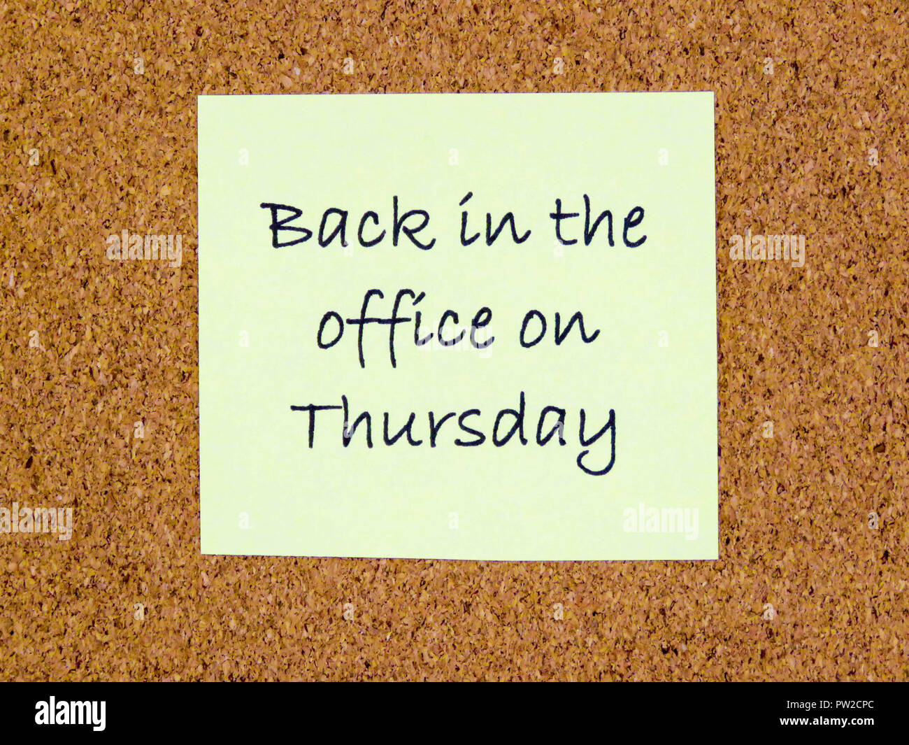 A yellow sticky note with back in the office on Thursday written on it ...