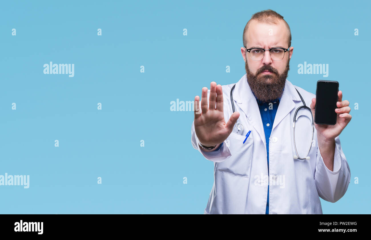 Young doctor man showing smartphone screen over isolated background ...