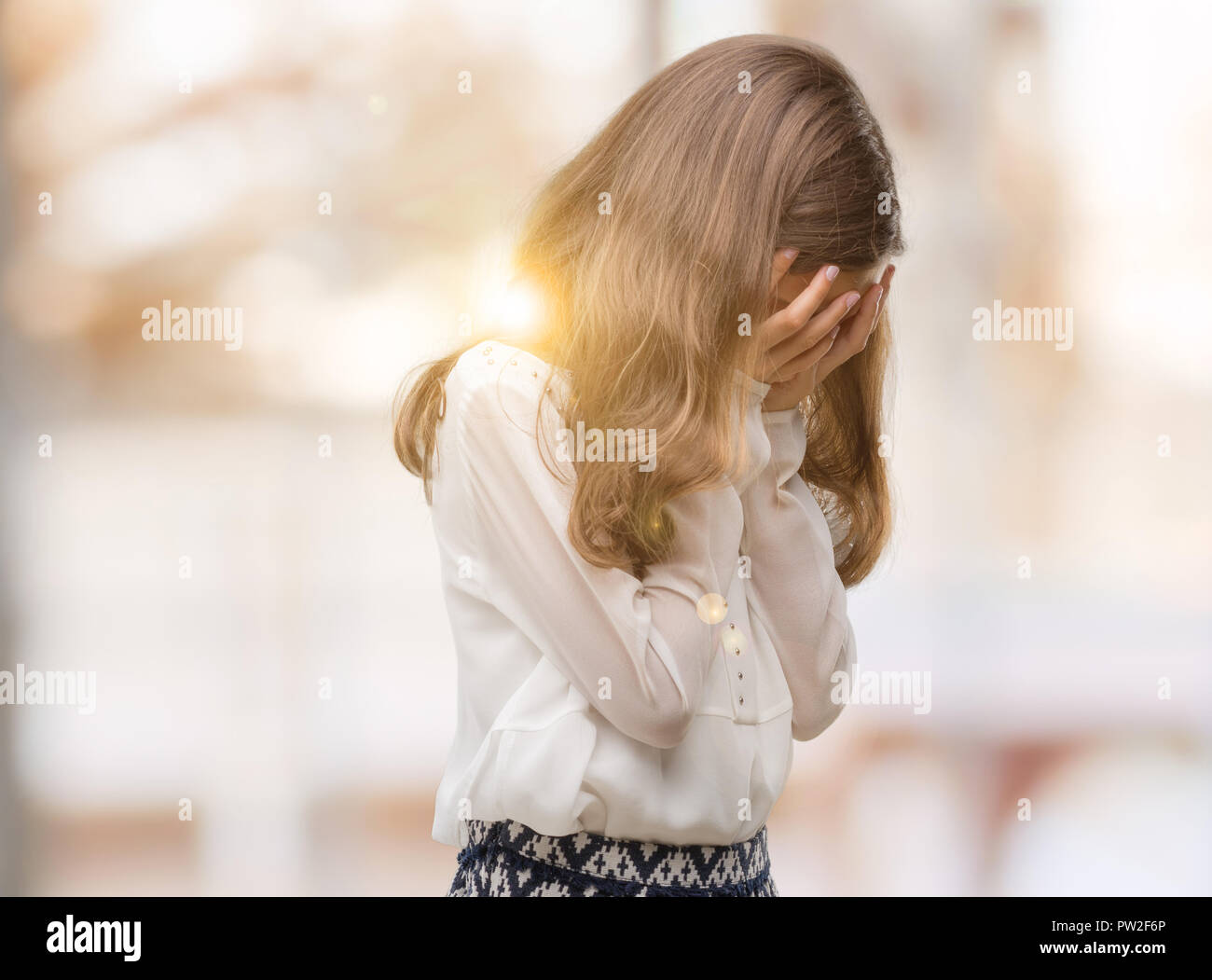 Brunette hispanic girl with sad expression covering face with hands ...