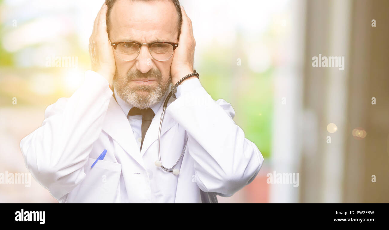 Doctor senior man, medical professional covering ears ignoring annoying ...