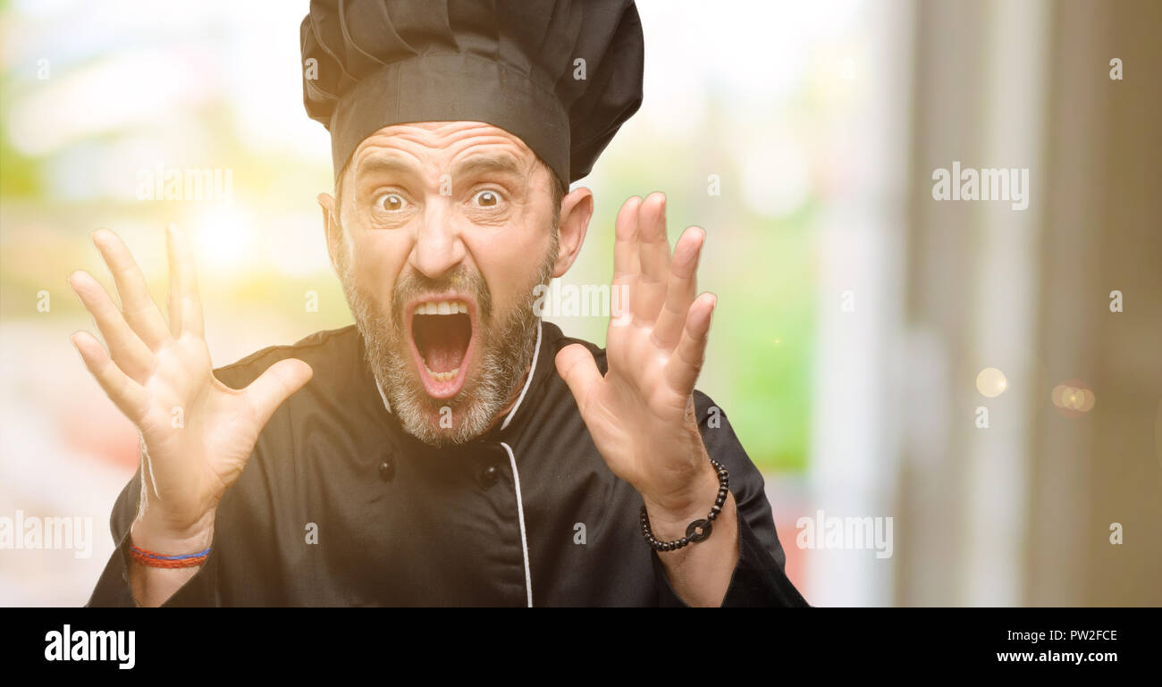 Senior cook man, wearing chef hat stressful keeping hands on head ...