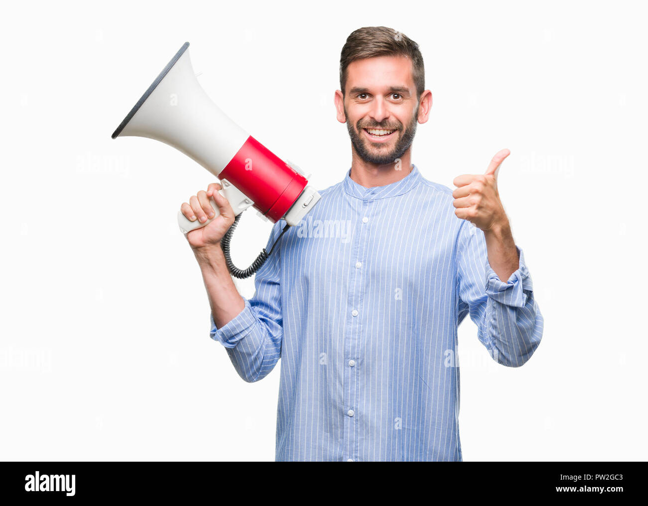 Young handsome man yelling through megaphone over isolated background ...