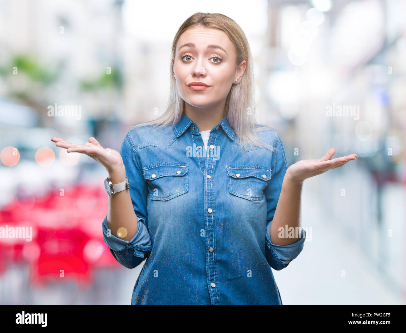 Young blonde woman over isolated background clueless and confused ...