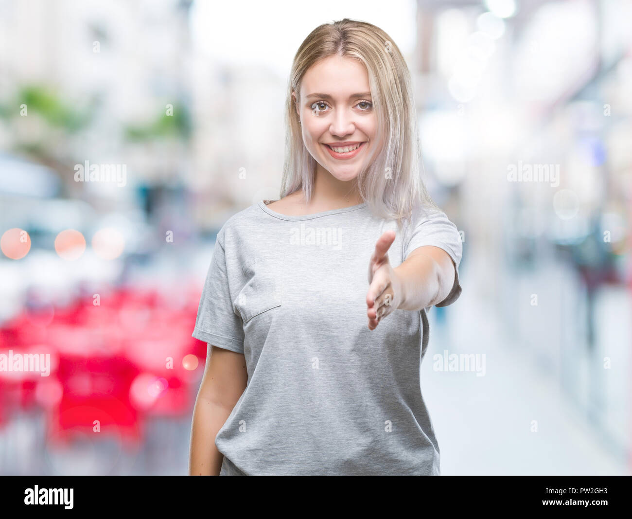 Young blonde woman over isolated background smiling friendly offering ...