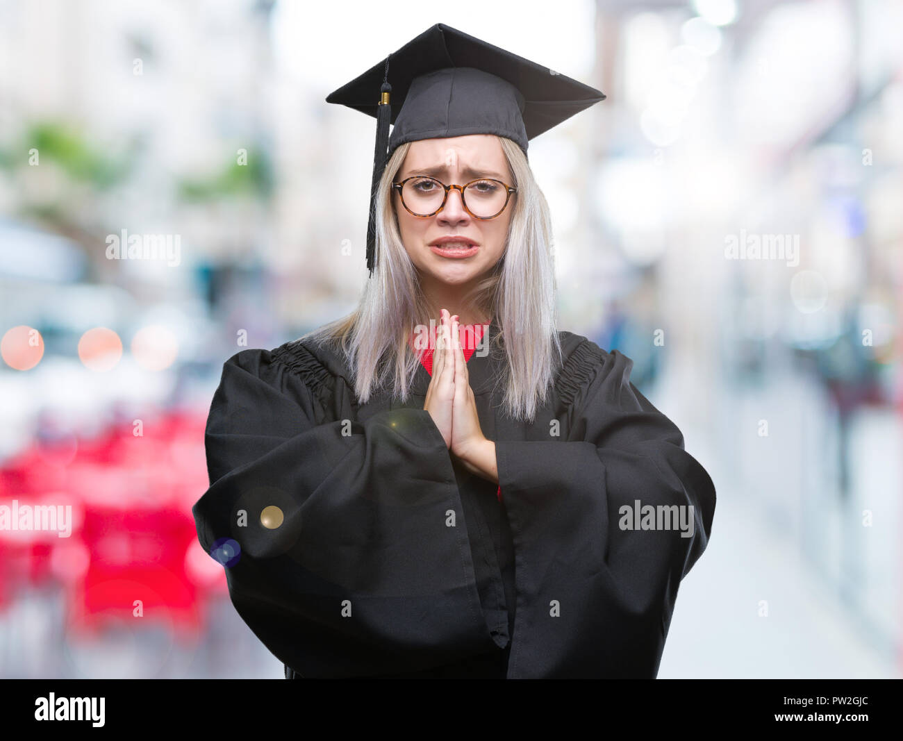 Young blonde woman wearing graduate uniform over isolated background ...
