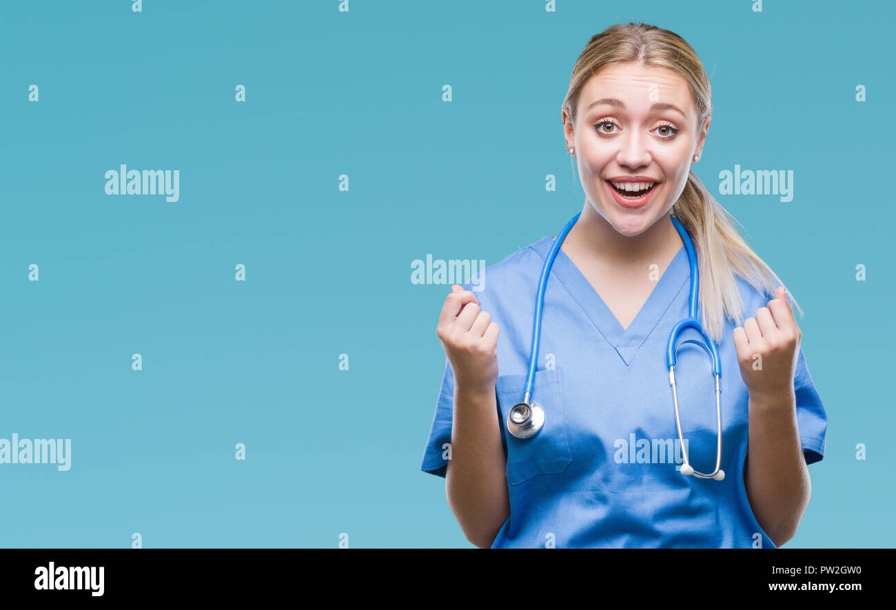 Young blonde surgeon doctor woman over isolated background celebrating ...
