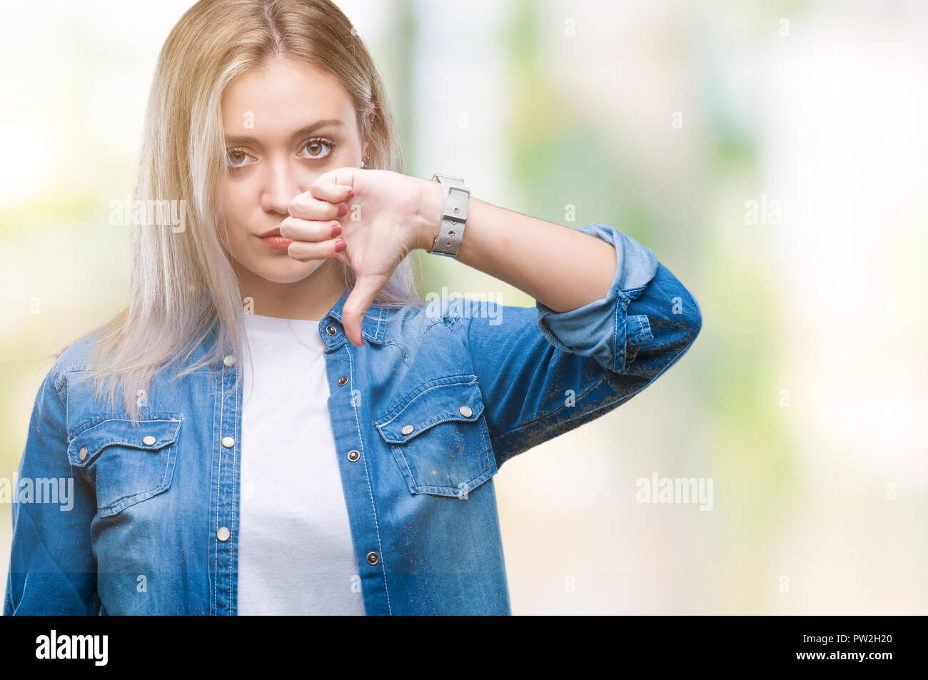 Young blonde woman over isolated background looking unhappy and angry ...