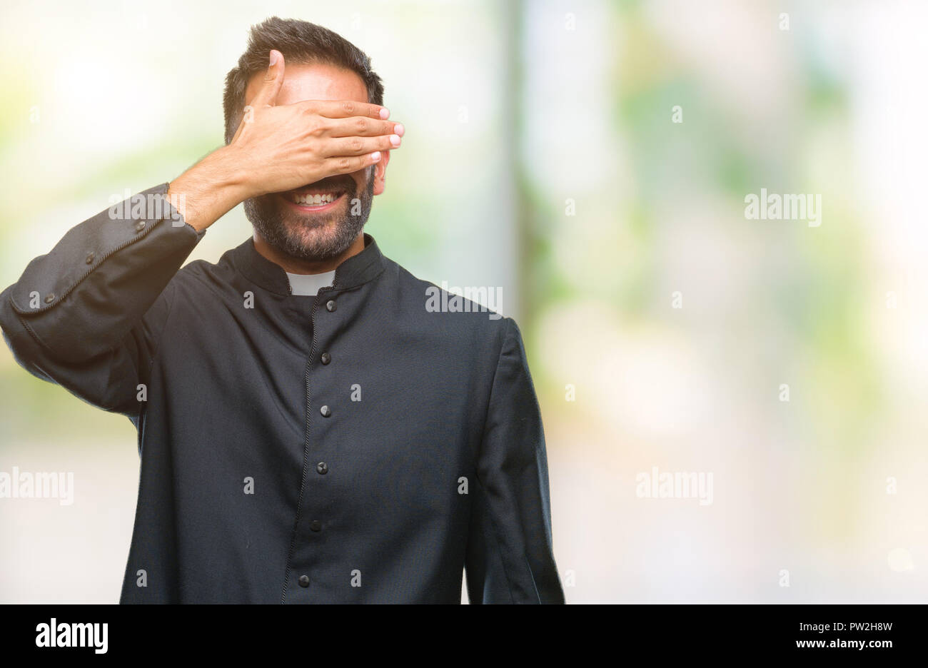 Adult hispanic catholic priest man over isolated background smiling and ...