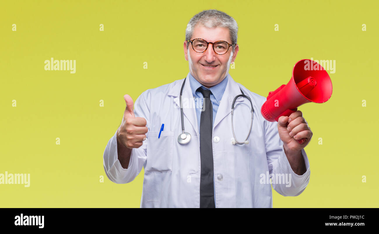Handsome senior doctor man yelling through megaphone over isolated ...