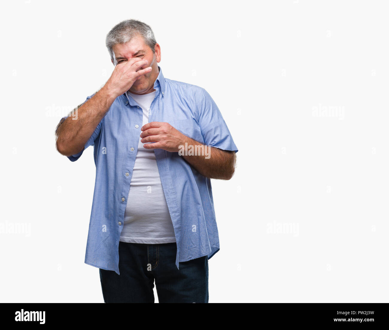Handsome senior man over isolated background smelling something stinky ...