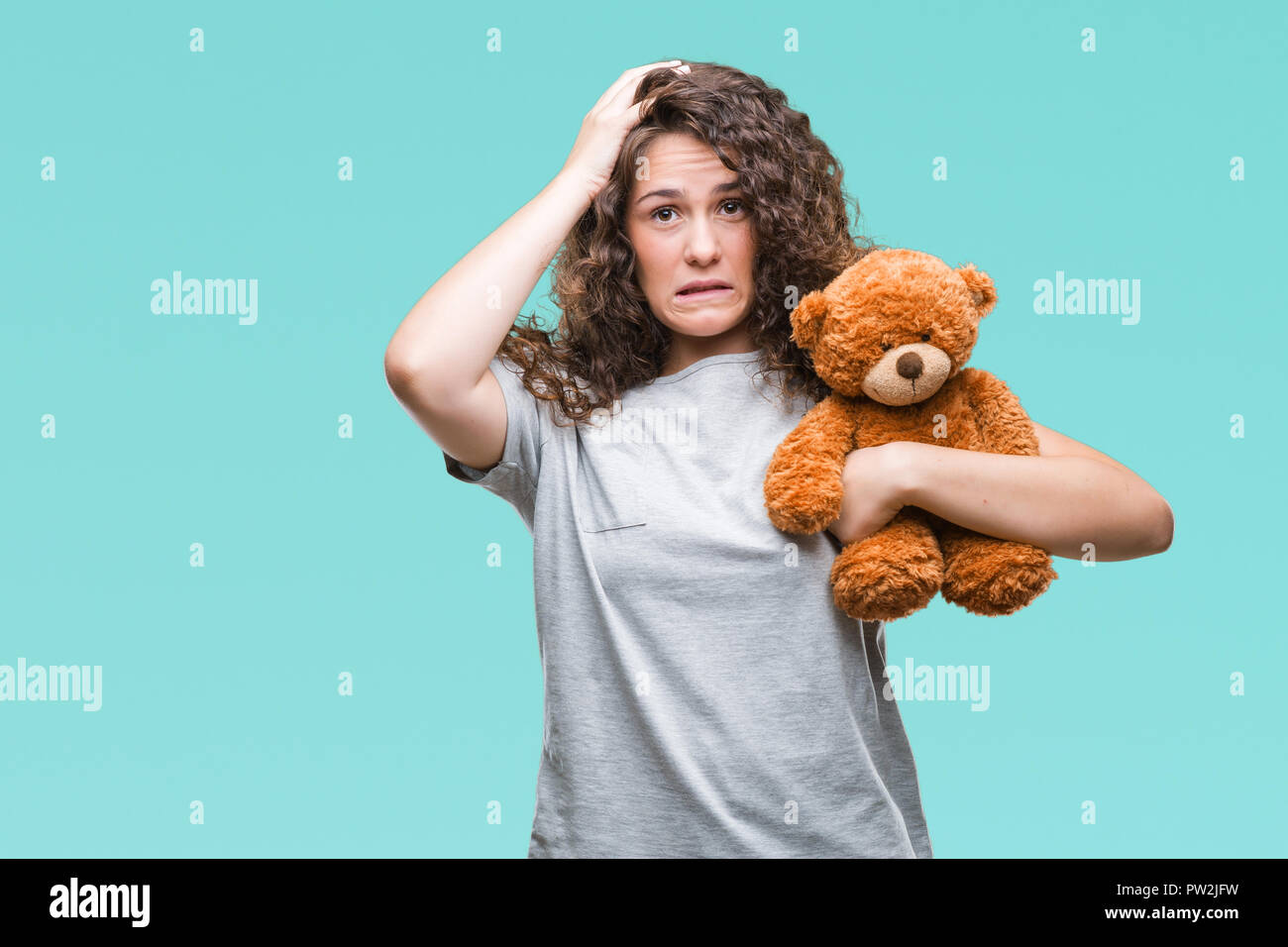 Young brunette girl holding teddy bear over isolated background ...