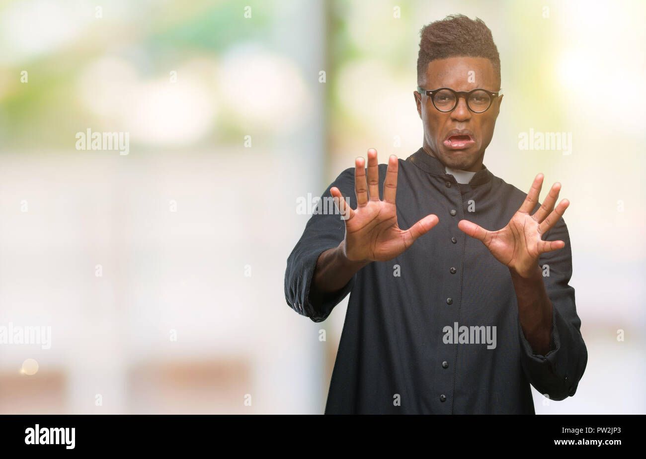 Young african american priest man over isolated background afraid and ...