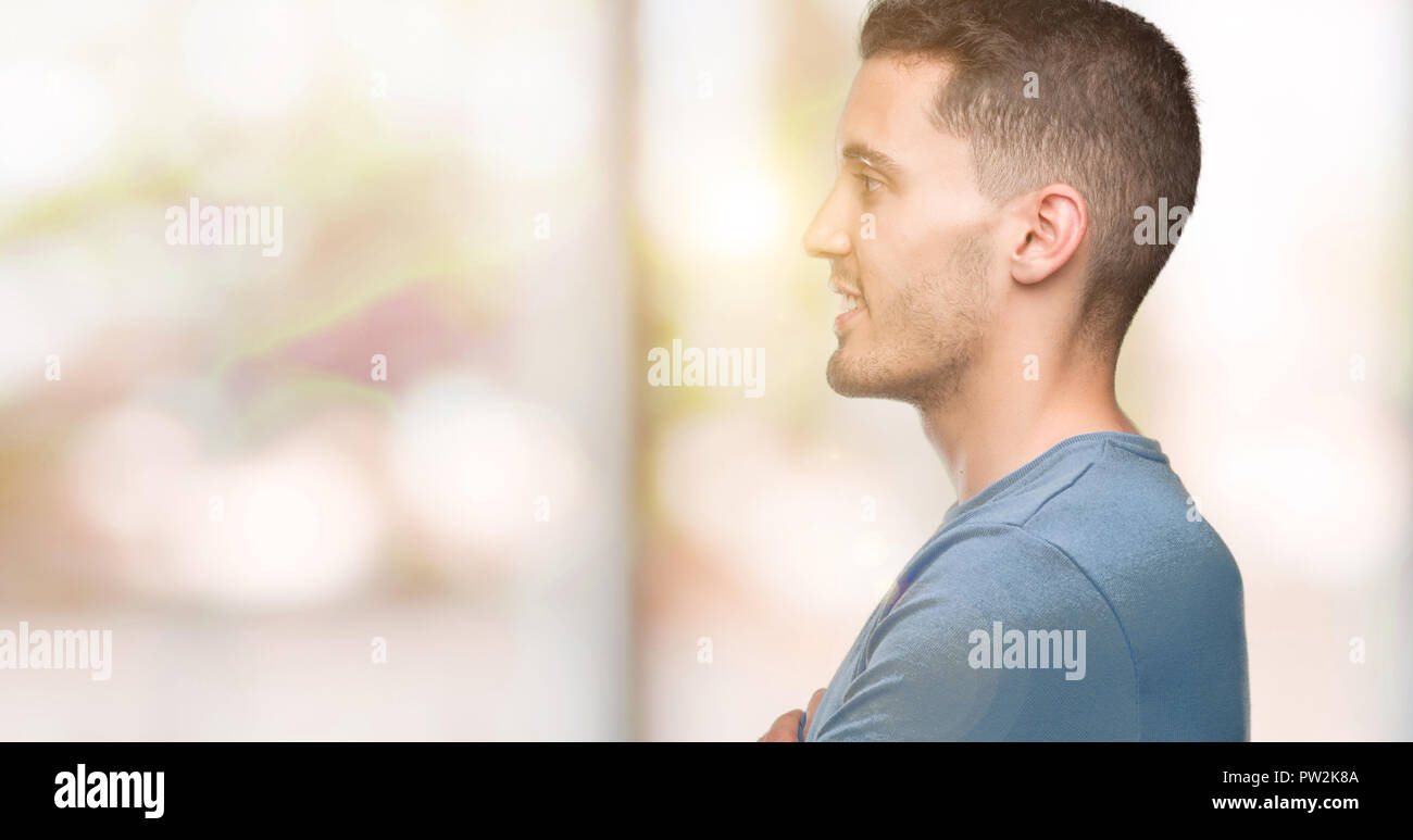 Handsome young casual man looking to side, relax profile pose with ...