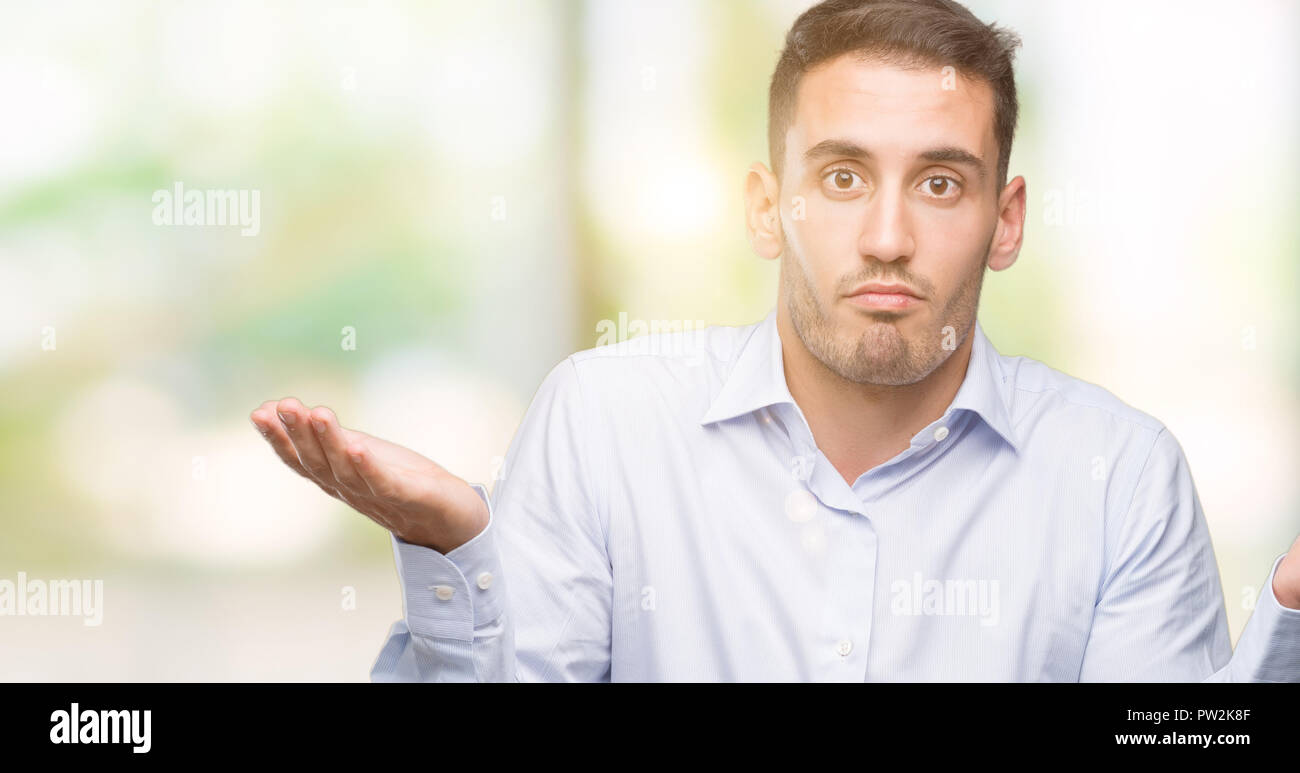 Confused businessman shrugging with raised arms hi-res stock ...