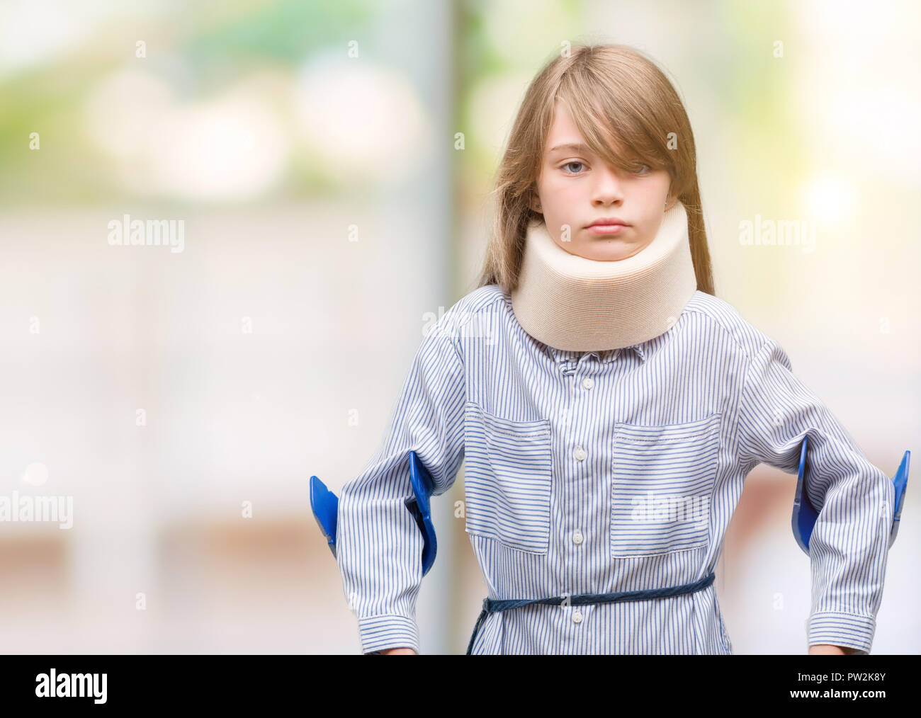 Young blonde child injured wearing neck collar and crutches with a ...