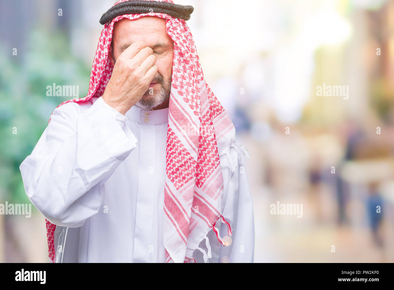 Senior arab man wearing keffiyeh over isolated background tired rubbing ...