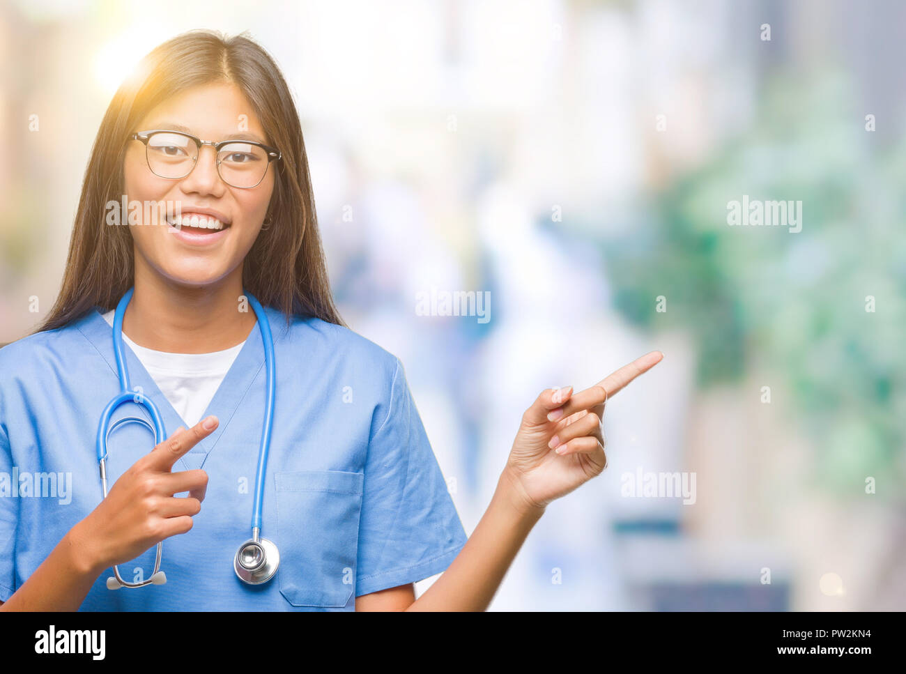 Young asian doctor woman over isolated background smiling and looking ...