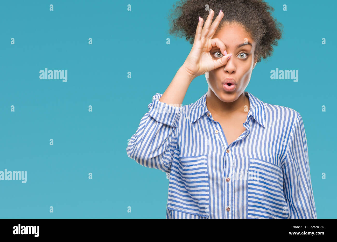 Young afro american woman over isolated background doing ok gesture ...
