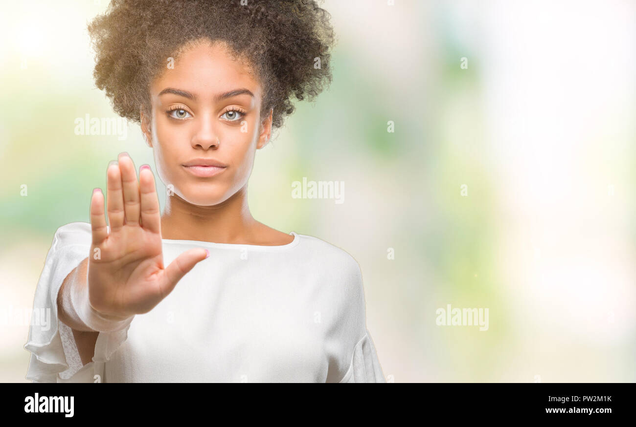 Young afro american woman over isolated background doing stop sing with ...