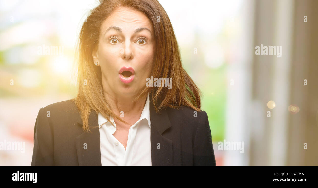 Middle age woman wearing jacket scared in shock, expressing panic and ...