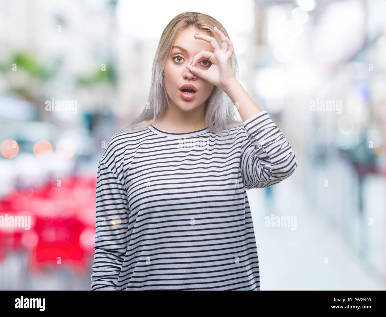 Young blonde woman over isolated background doing ok gesture shocked ...