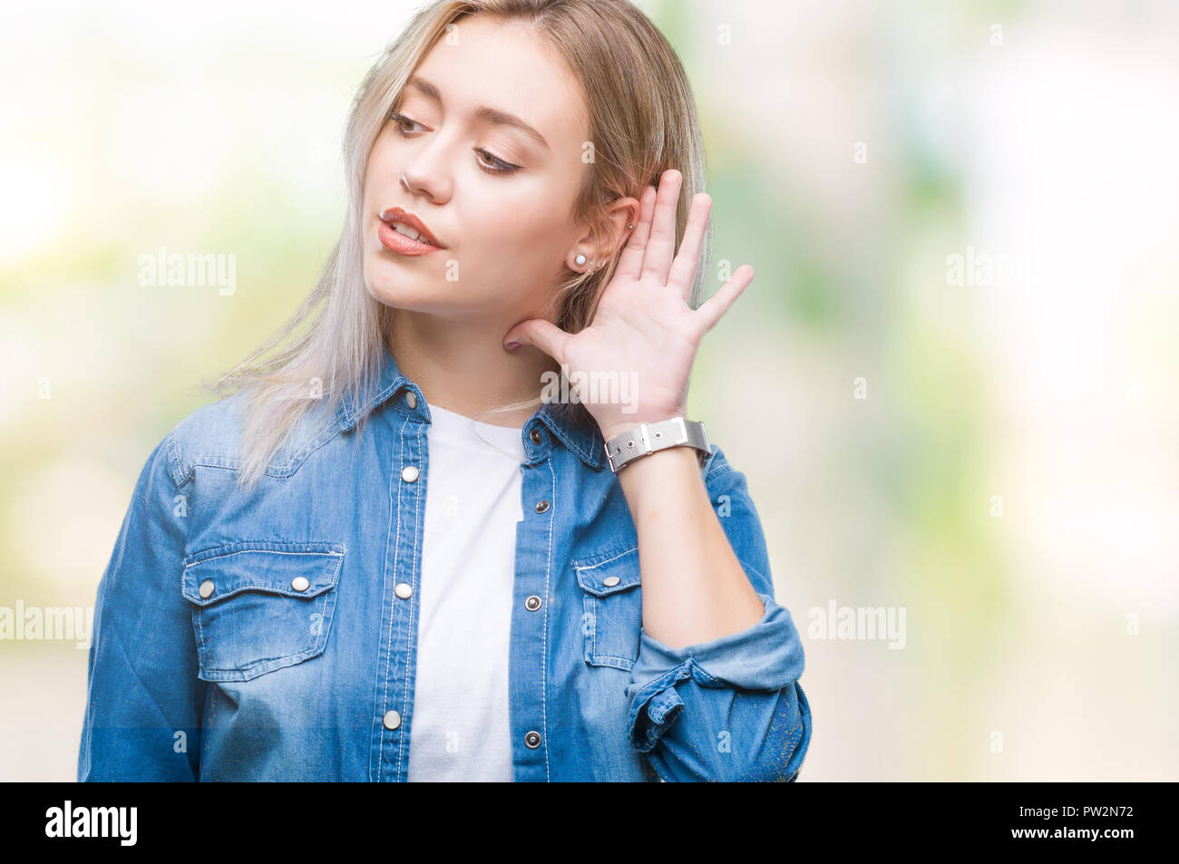 Young blonde woman over isolated background smiling with hand over ear ...