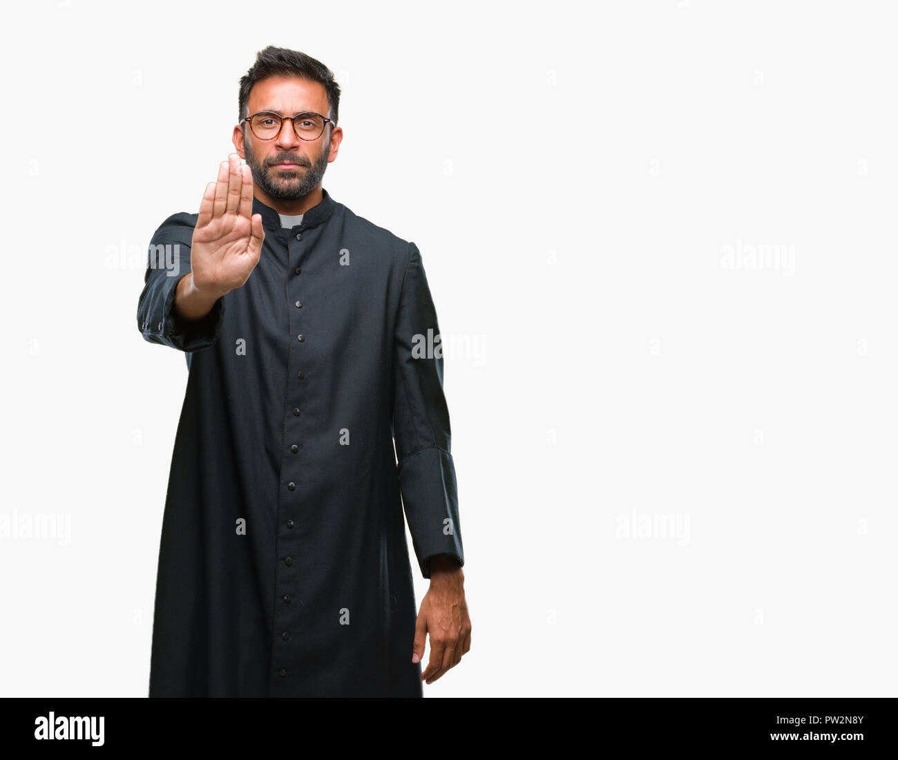 Adult hispanic catholic priest man over isolated background doing stop ...