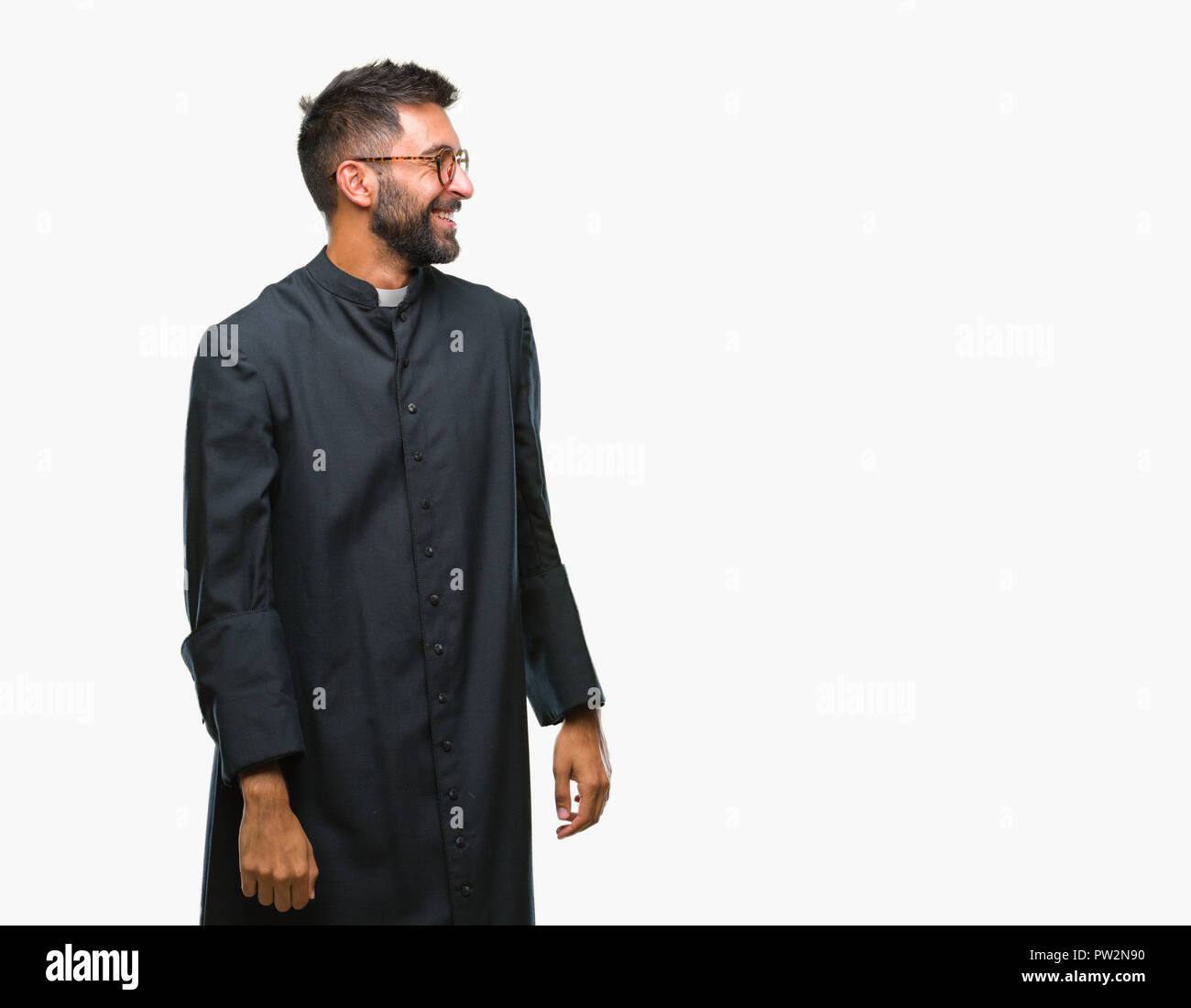 Adult hispanic catholic priest man over isolated background looking ...