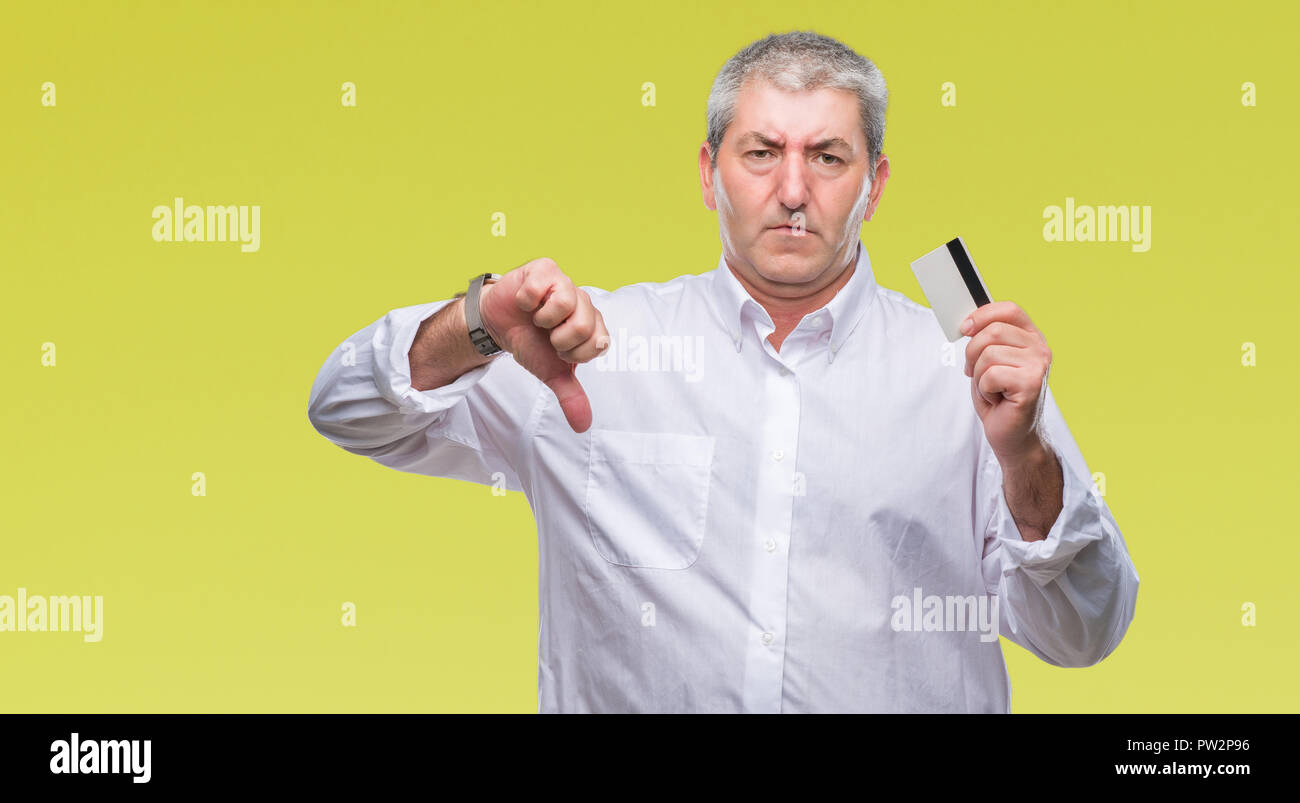 Handsome senior man holding credit card over isolated background with ...