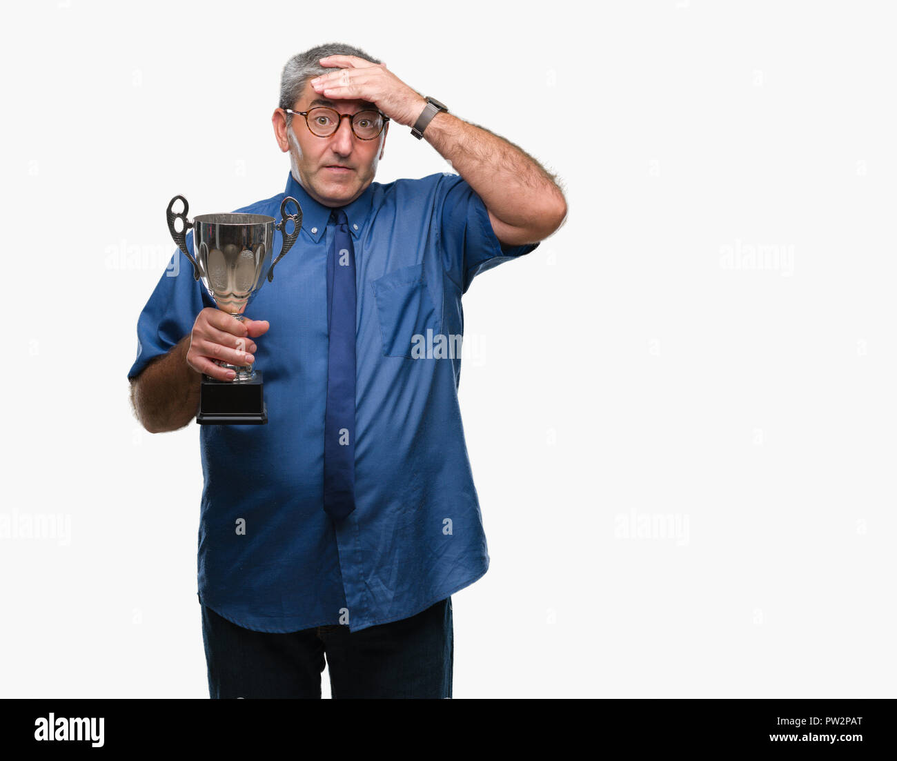 Handsome senior successful man holding trophy over isolated background ...