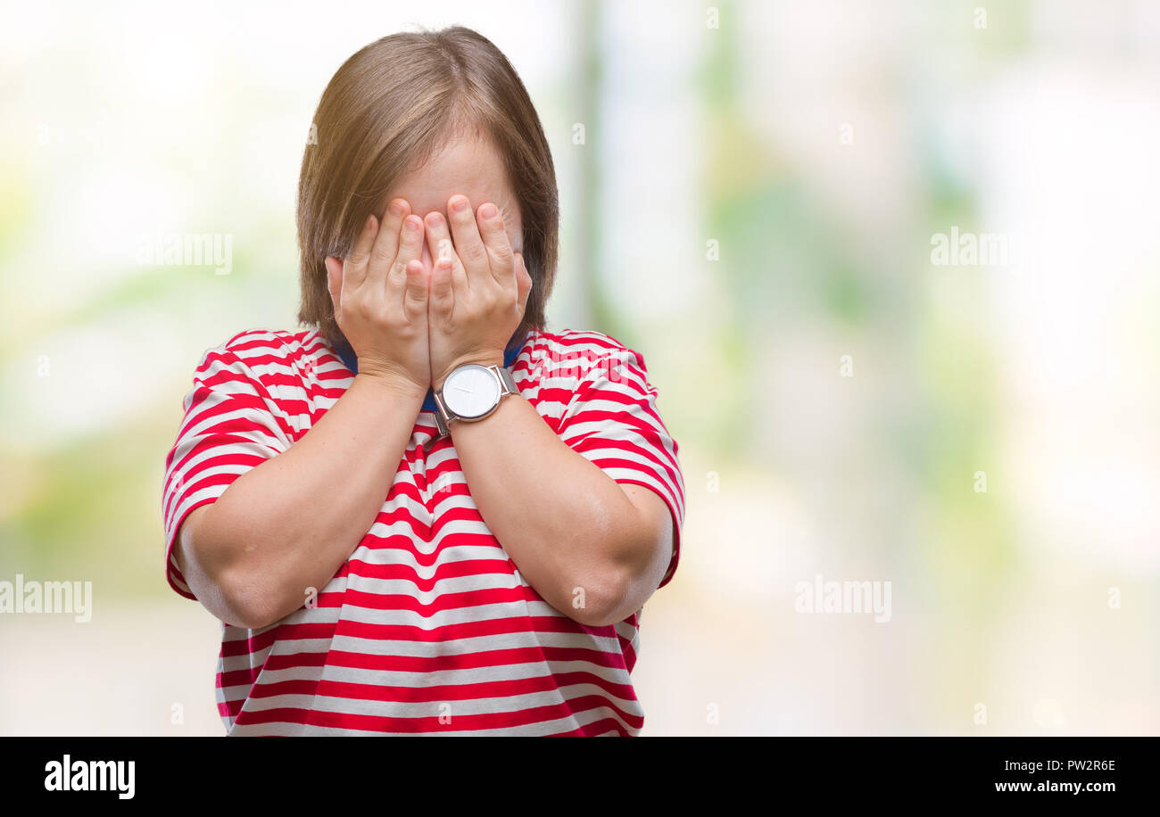 Young adult woman with down syndrome over isolated background with sad ...