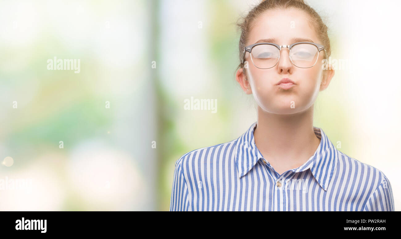 Young blonde business woman puffing cheeks with funny face. Mouth ...