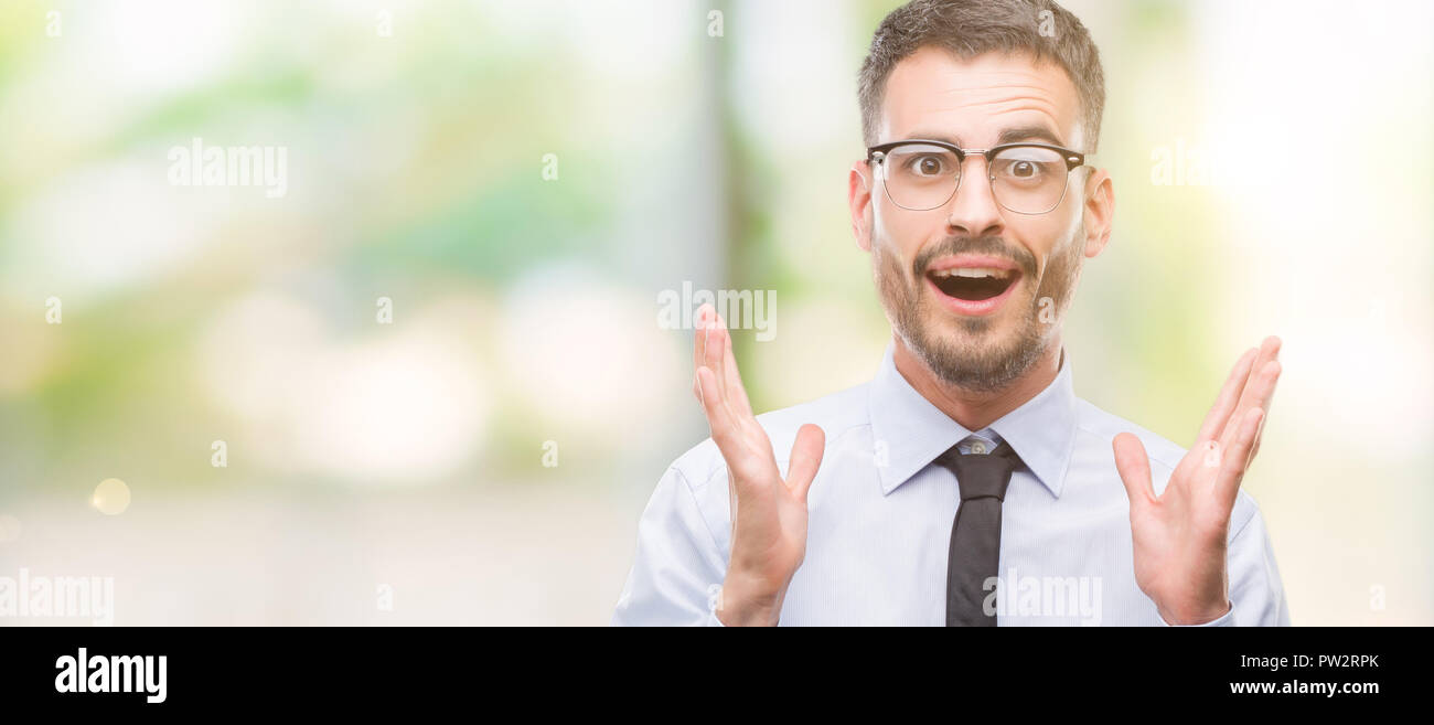 Young business man very happy and excited, winner expression ...