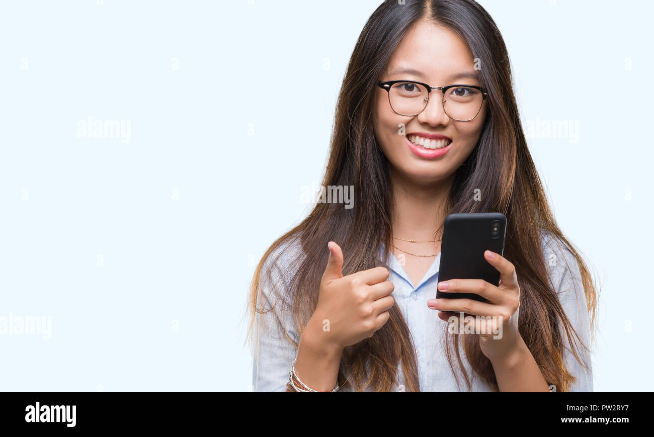 Young asian woman texting using smartphone over isolated background ...