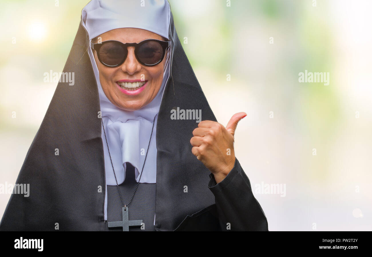 Middle age senior catholic nun woman wearing sunglasses over isolated ...
