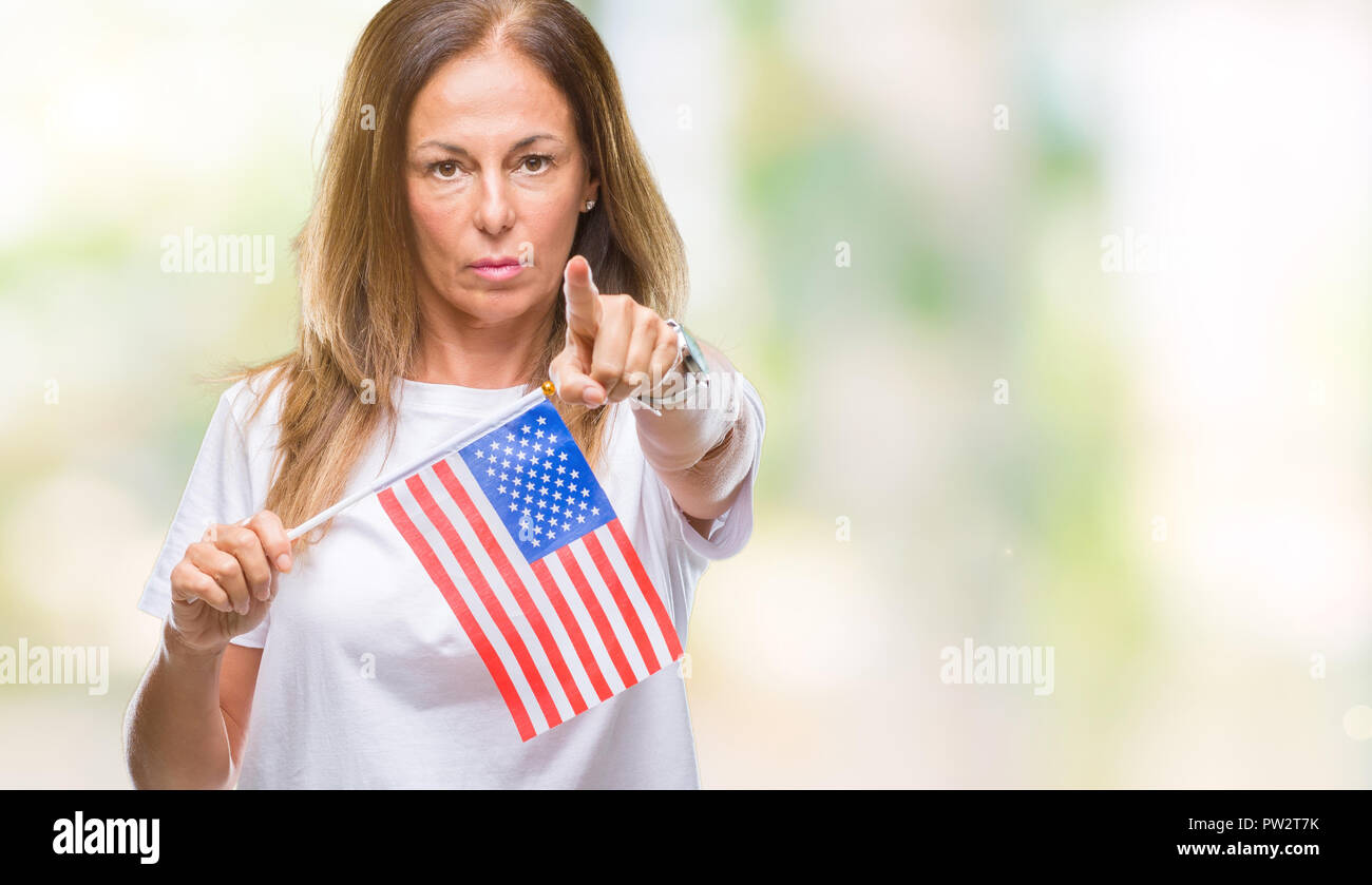Middle age hispanic woman holding flag of United States of America over ...