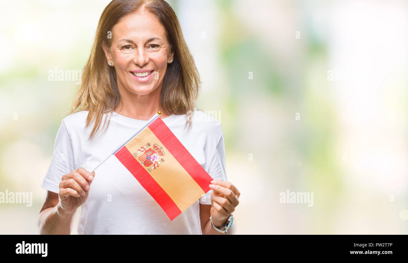 Middle age hispanic woman holding flag of Spain over isolated ...