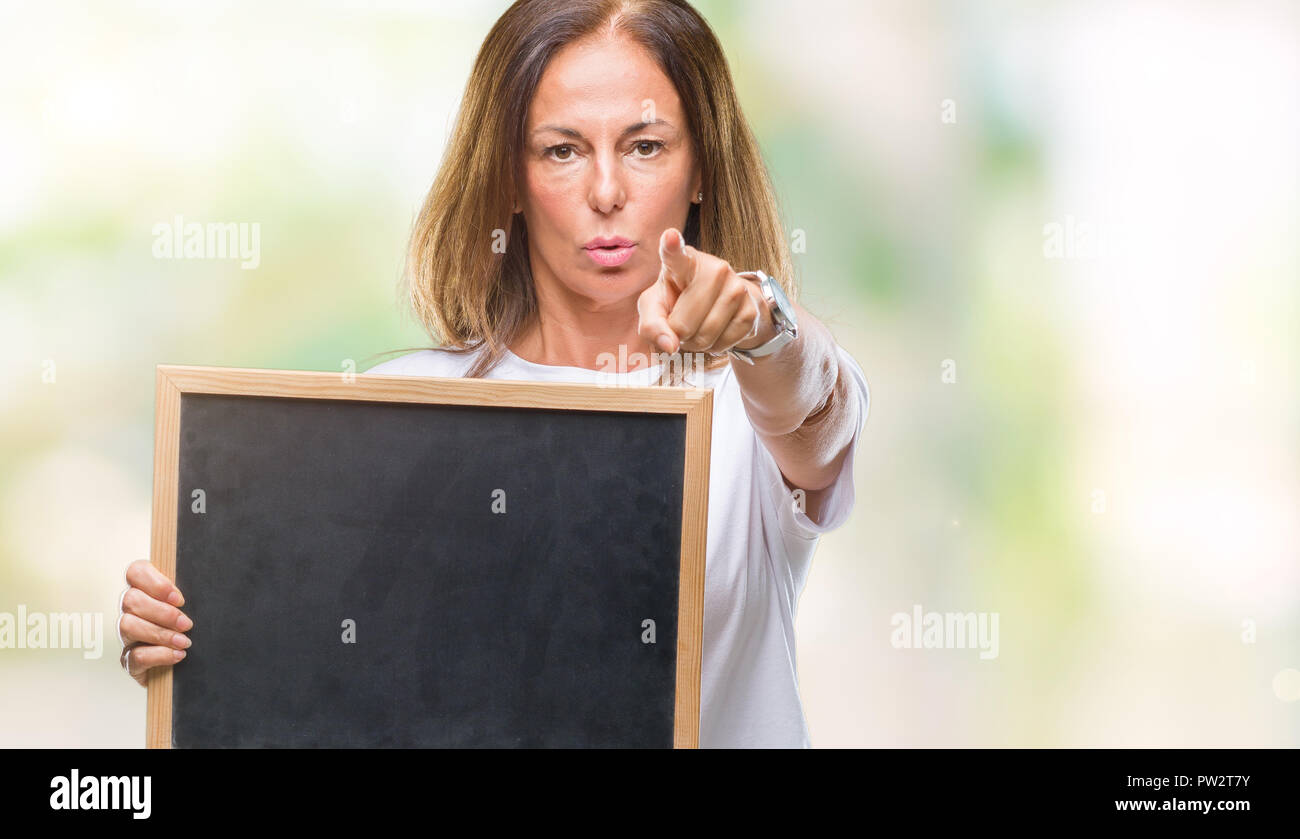 Middle age hispanic woman holding blackboard over isolated background ...