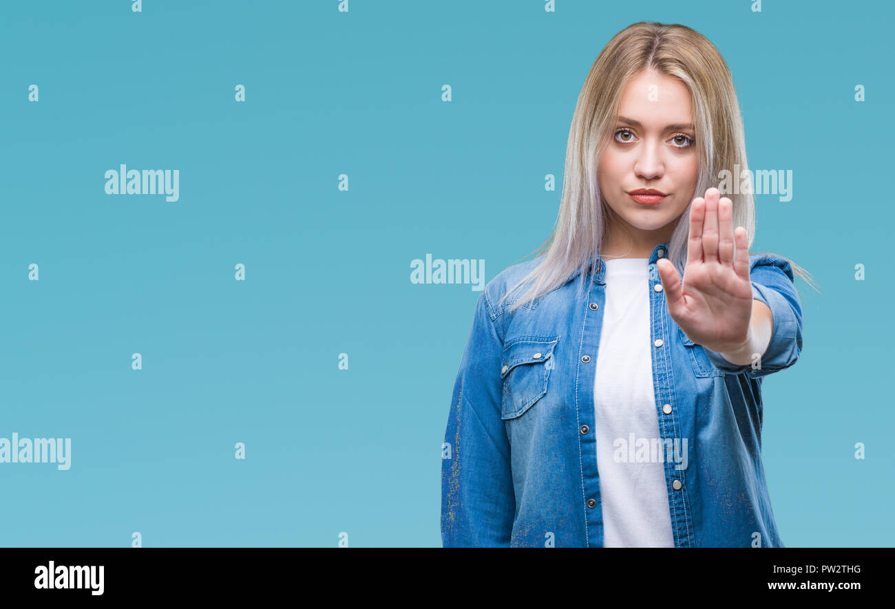 Young blonde woman over isolated background doing stop sing with palm ...
