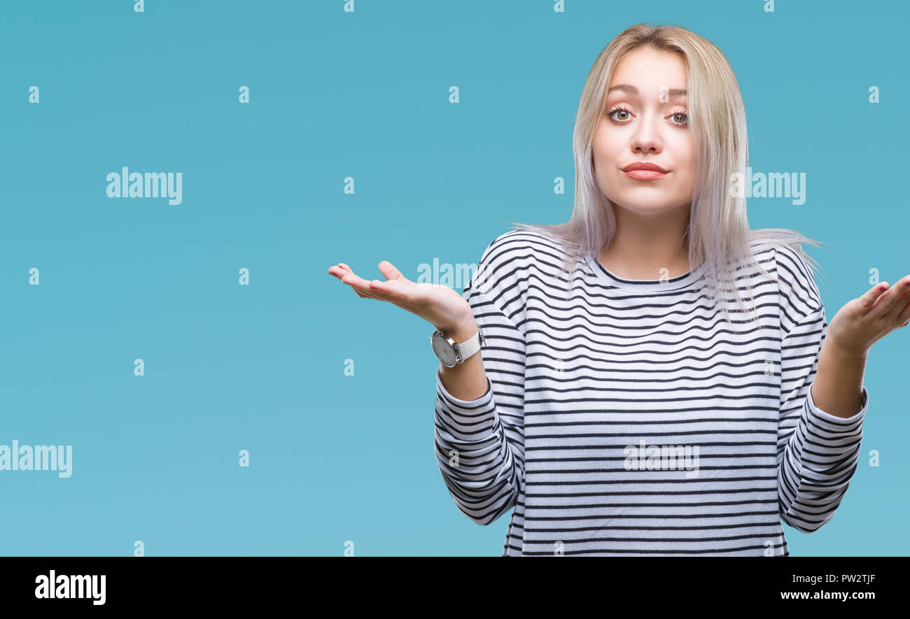 Young blonde woman over isolated background clueless and confused ...