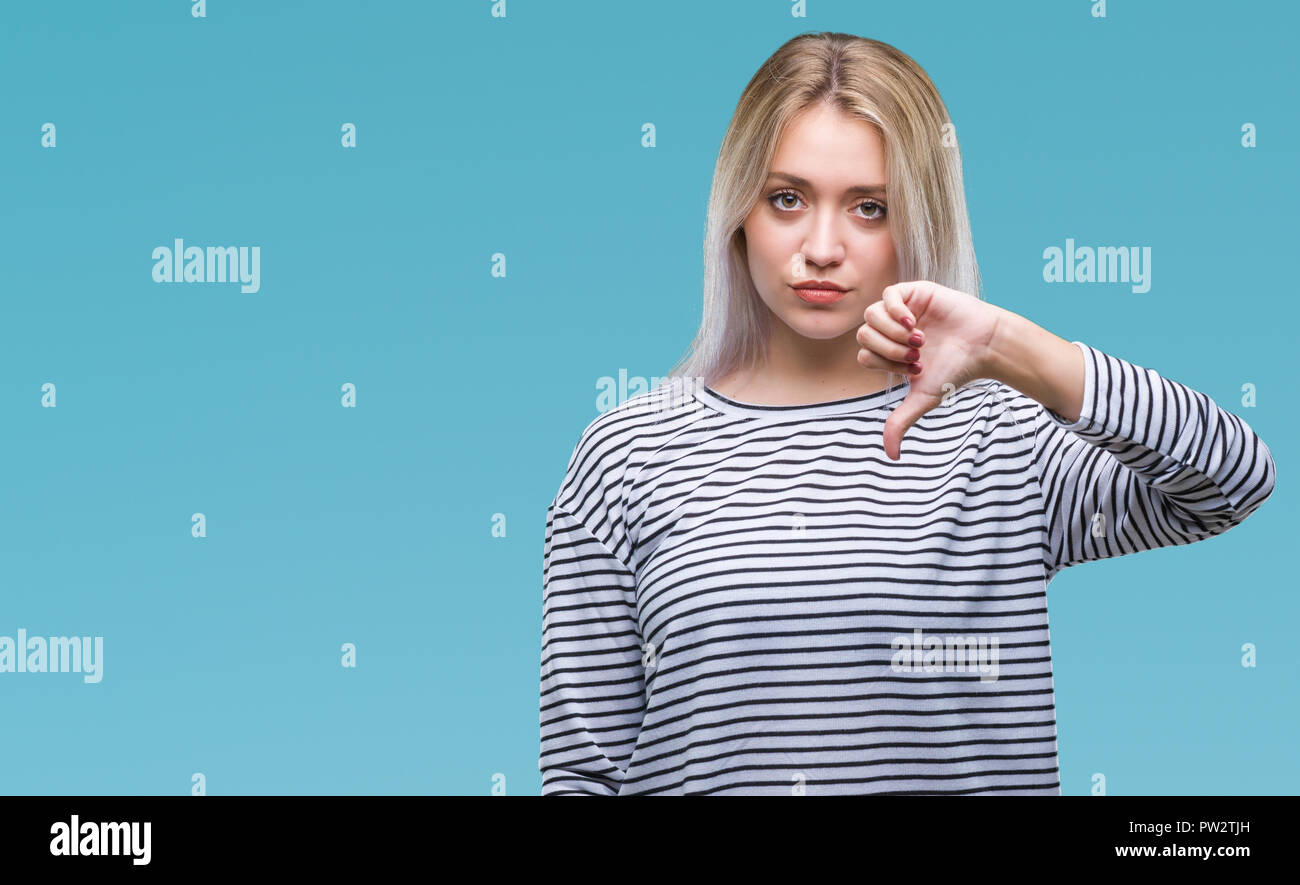Young blonde woman over isolated background looking unhappy and angry ...