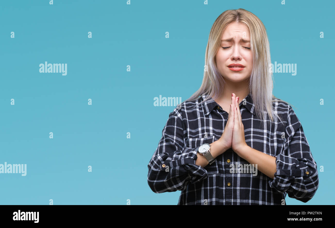 Young blonde woman over isolated background begging and praying with ...
