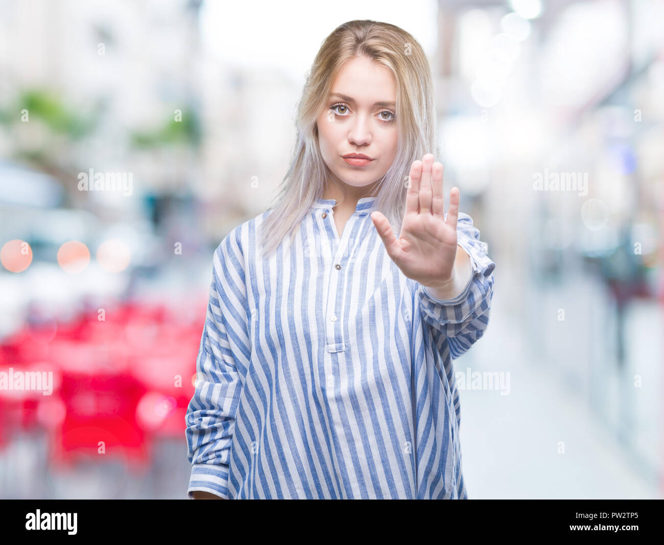 Young blonde woman over isolated background doing stop sing with palm ...