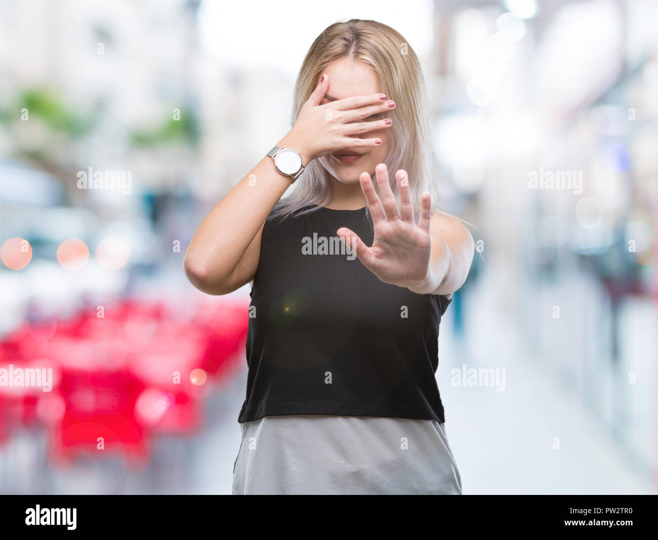 Young blonde woman over isolated background covering eyes with hands ...